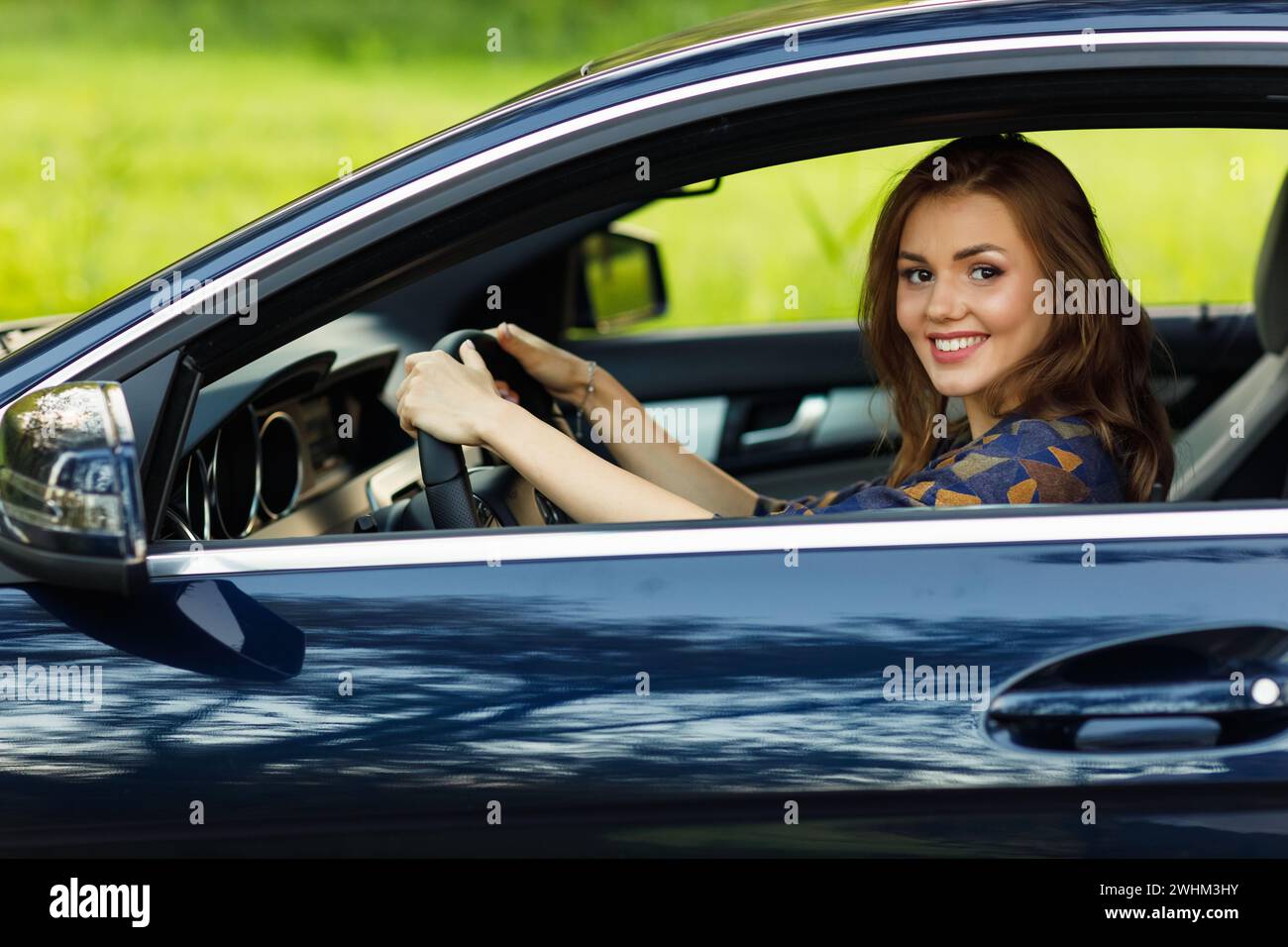 Happy woman driver at car smiling. Cute young happy brunette female ...
