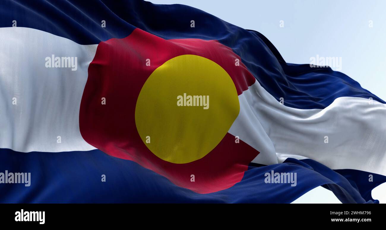 Colorado state flag waving in the wind on a clear day. Three blue ...