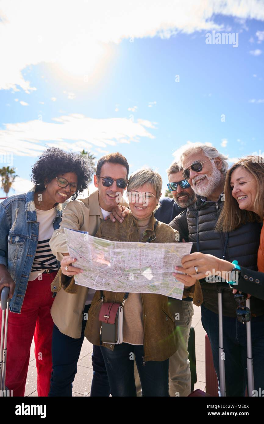 Group diverse middle-aged tourist people standing looking at travel map ...