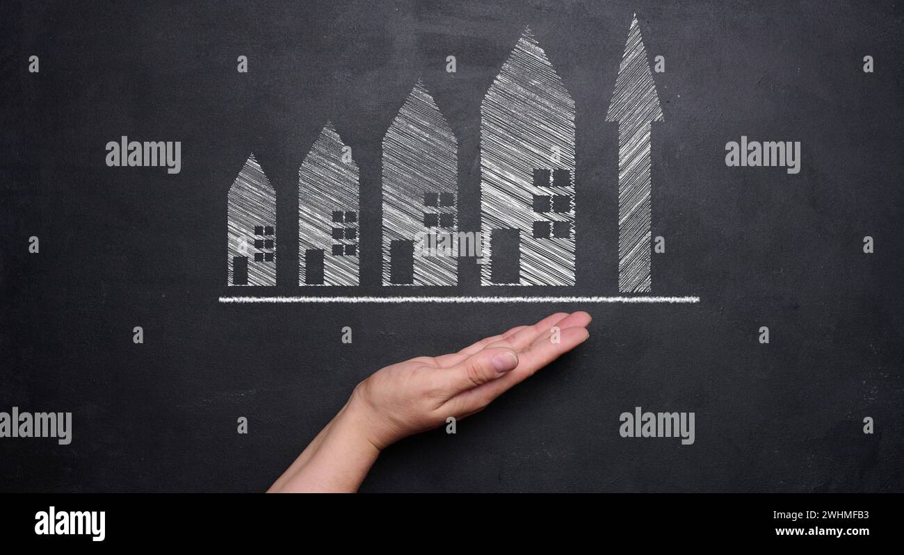 Chalk drawn houses and up arrow. the concept of rising real estate ...
