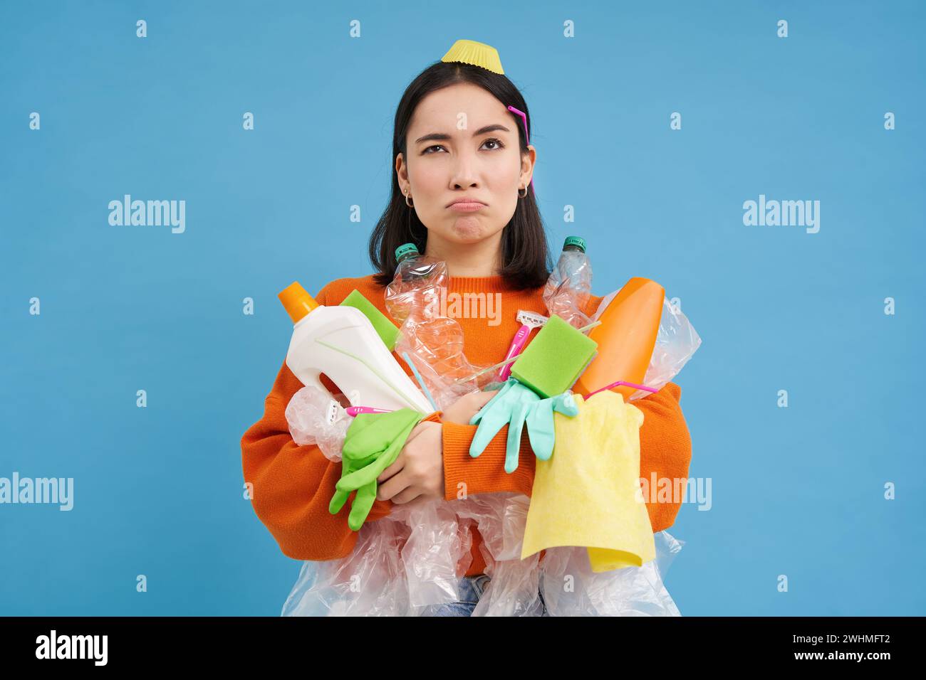 Complicated girl with garbage on her face, plastic empty bottles and ...
