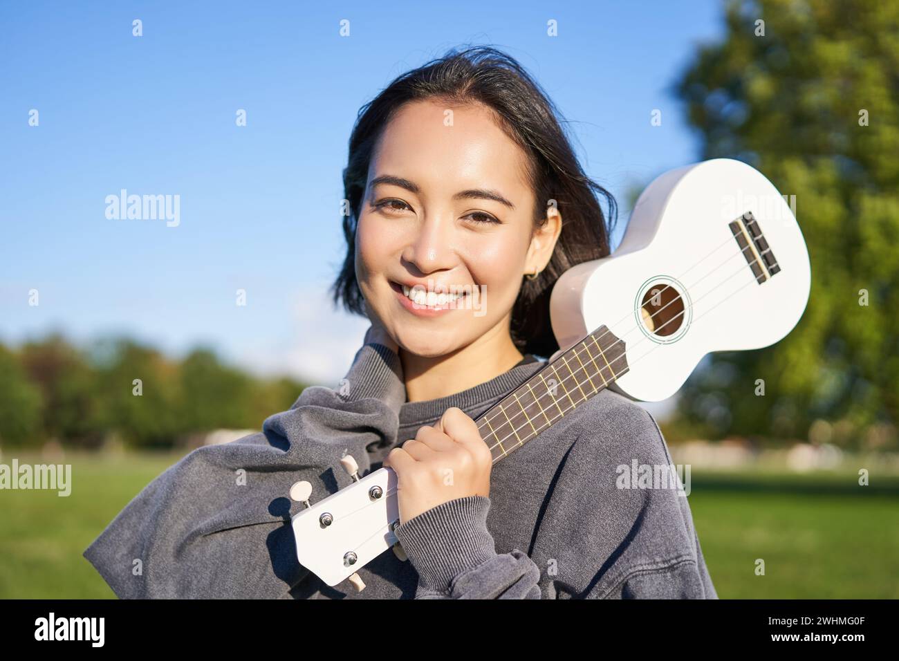 Portrait of beautiful smiling girl with ukulele, asian woman with ...
