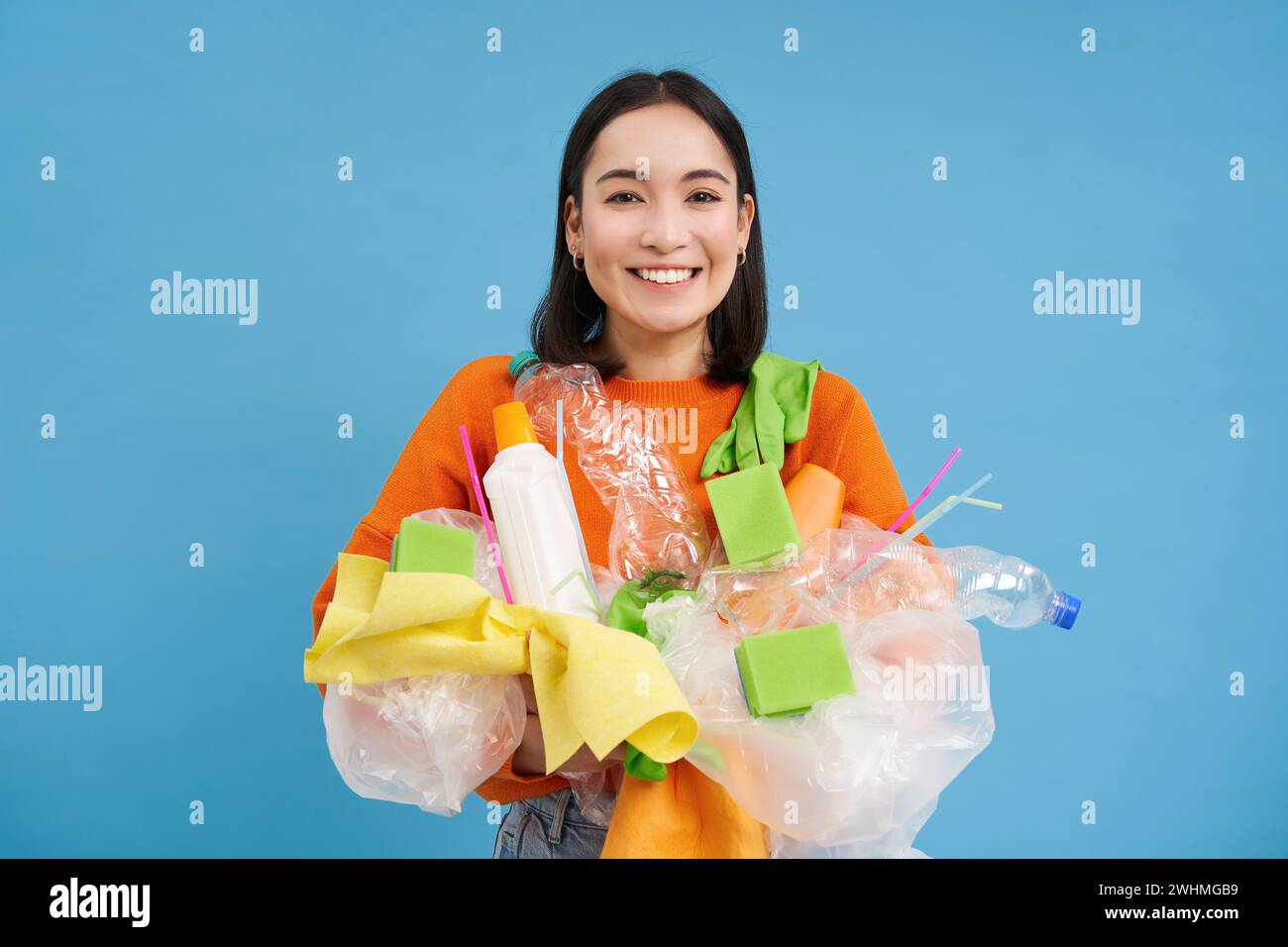 Happy girl looks at plastic garbage, sorting her waste for recycling ...