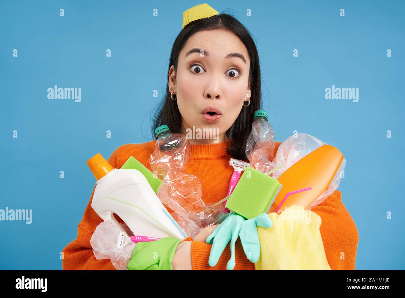 Close up of girl with surprised face, holds empty plastic bottles and ...