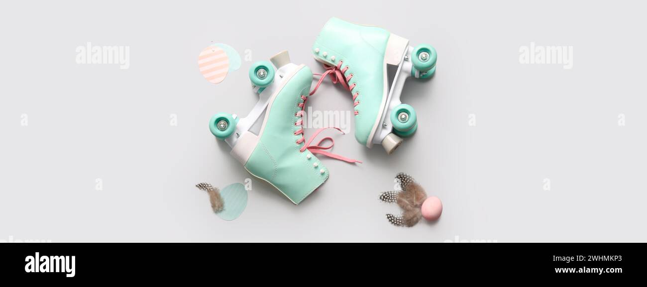 Vintage roller skates with Easter eggs and feathers on light background ...