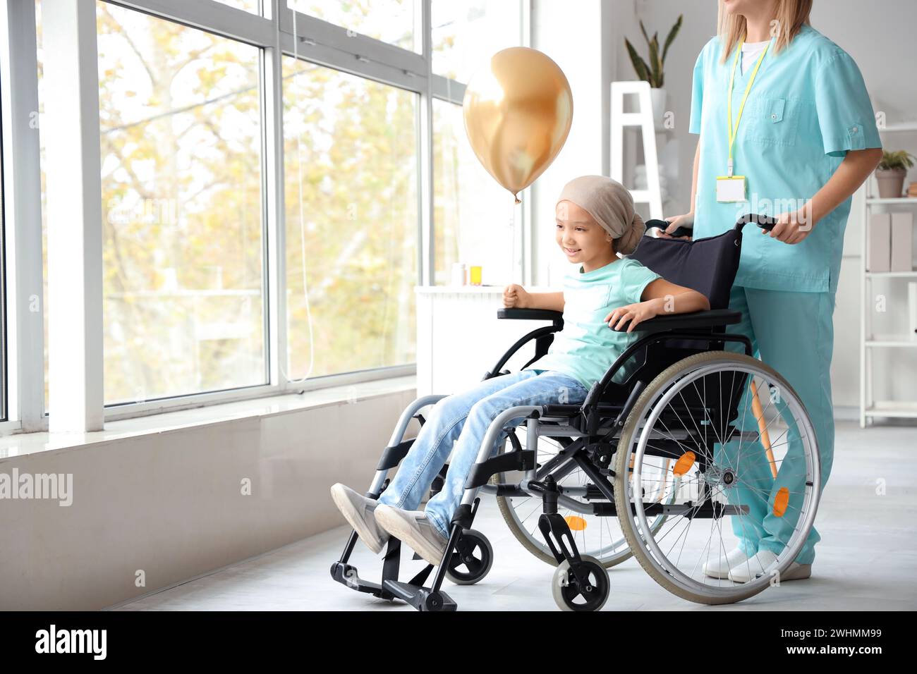 Little Asian girl after chemotherapy in wheelchair with balloon and ...