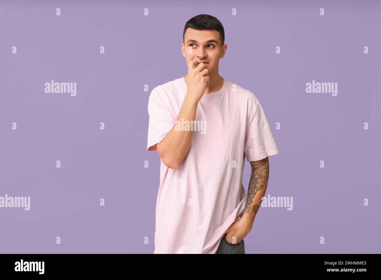 Handsome ashamed young man on lilac background Stock Photo - Alamy