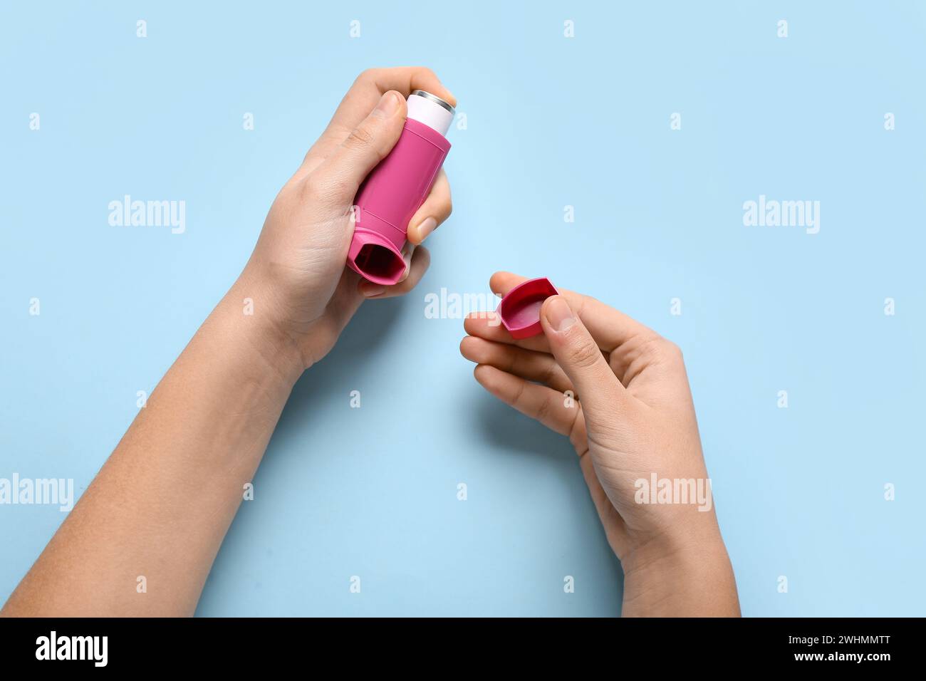 Child's hands with asthma inhaler on blue background Stock Photo - Alamy