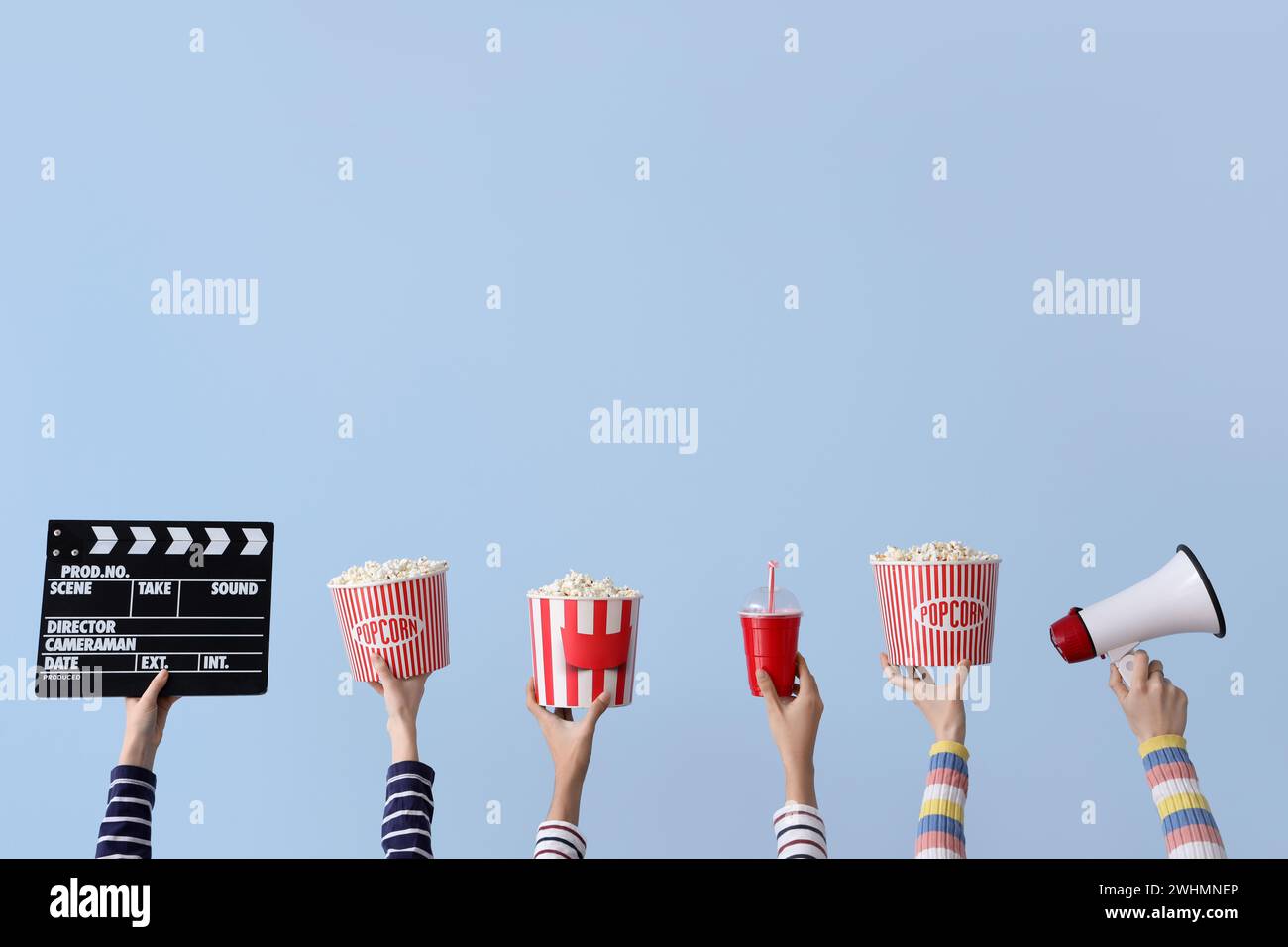 Many hands with movie clapper, buckets of popcorn and megaphone on blue ...
