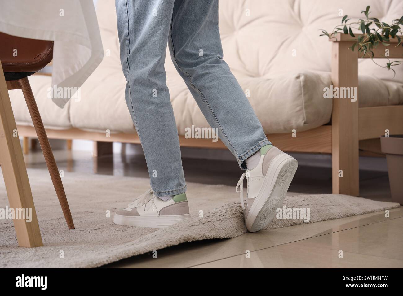 Young woman tripping over carpet at home. Trauma concept Stock Photo ...