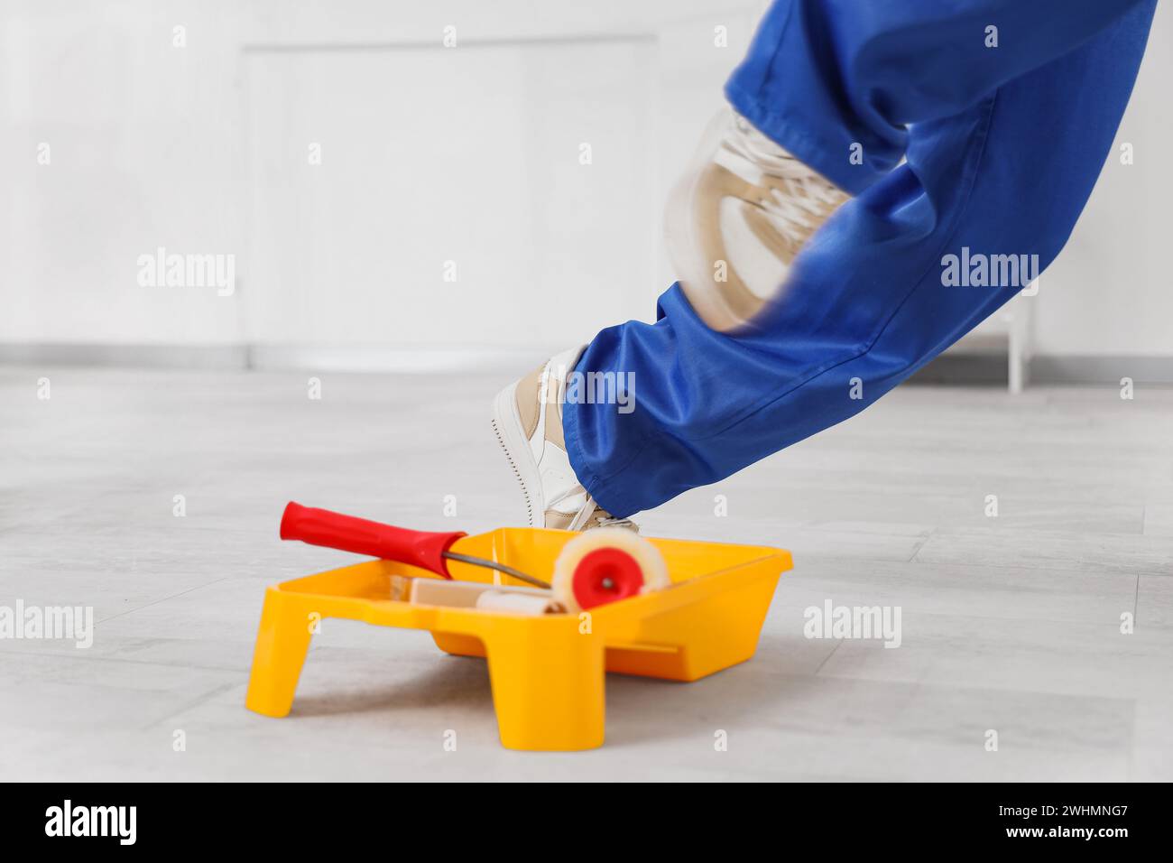 Female painter tripping over tray in room, closeup. Trauma concept ...