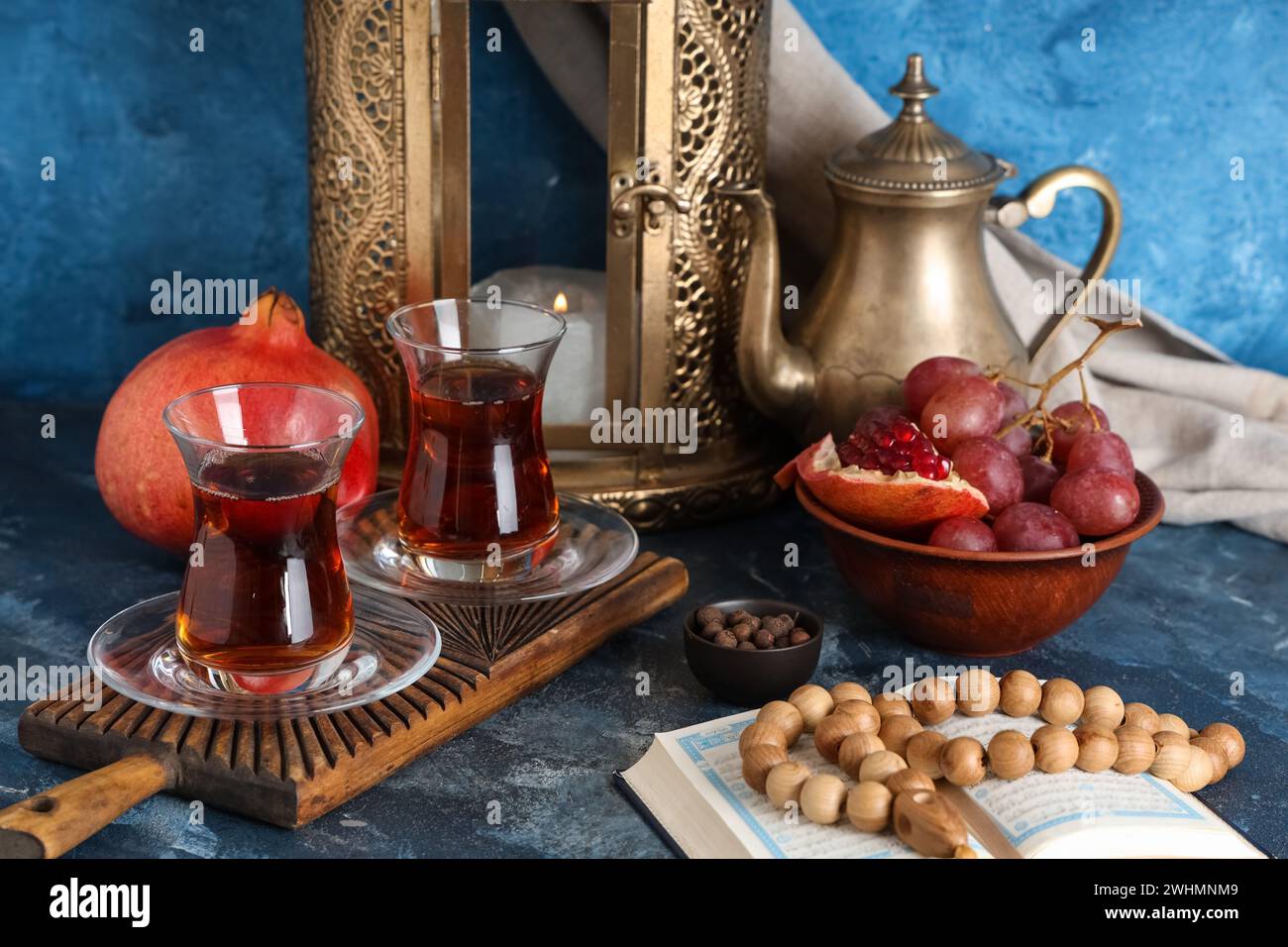 Turkish tea, fruits, Koran and prayer beads and on blue table. Ramadan ...