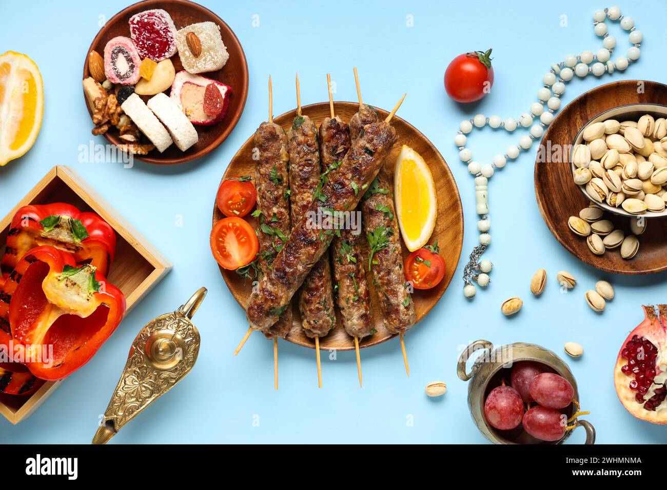 Traditional Eastern dishes, Aladdin lamp and prayer beads on blue ...