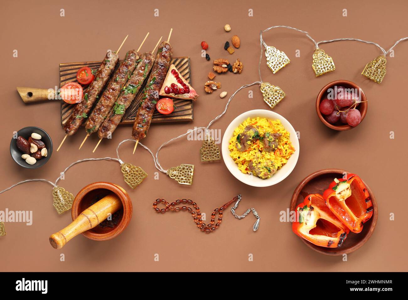 Traditional Eastern dishes, prayer beads and Muslim decor on brown ...