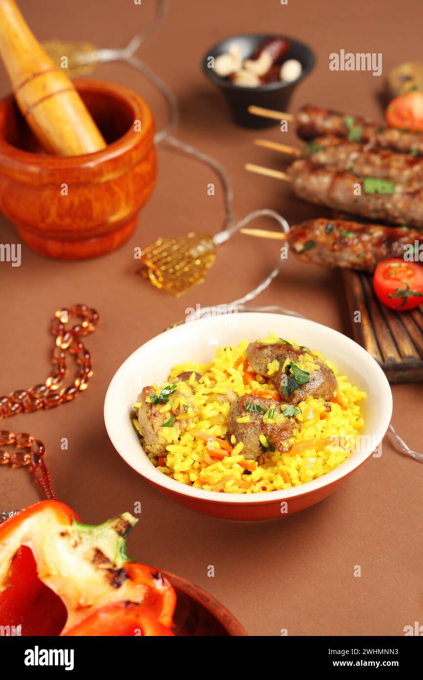 Traditional Eastern dishes, prayer beads and Muslim decor on brown ...