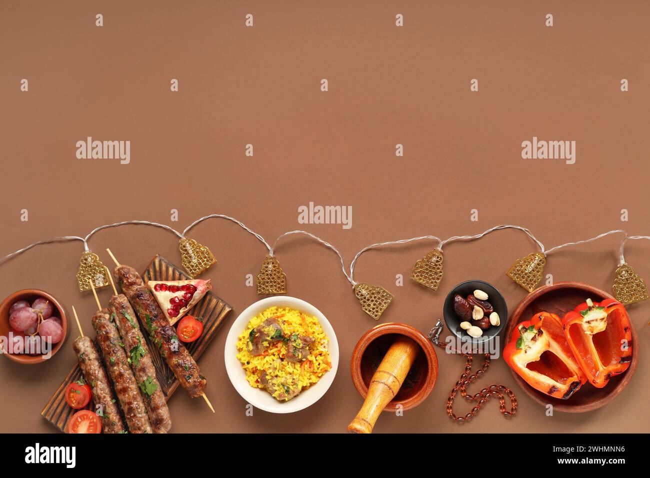 Traditional Eastern dishes, prayer beads and Muslim decor on brown ...