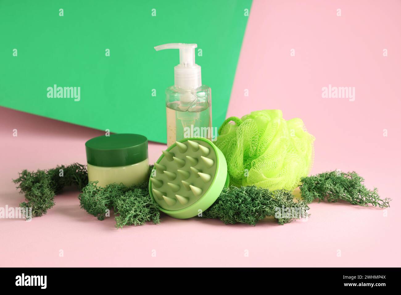 Hair scalp massager with bottle of shampoo and bath sponge on colorful ...