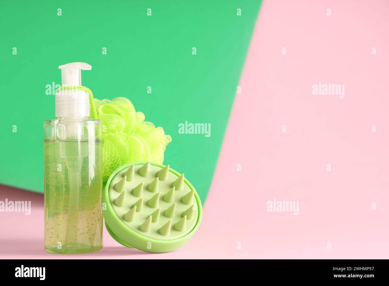 Hair scalp massager with bottle of shampoo and bath sponge on colorful ...