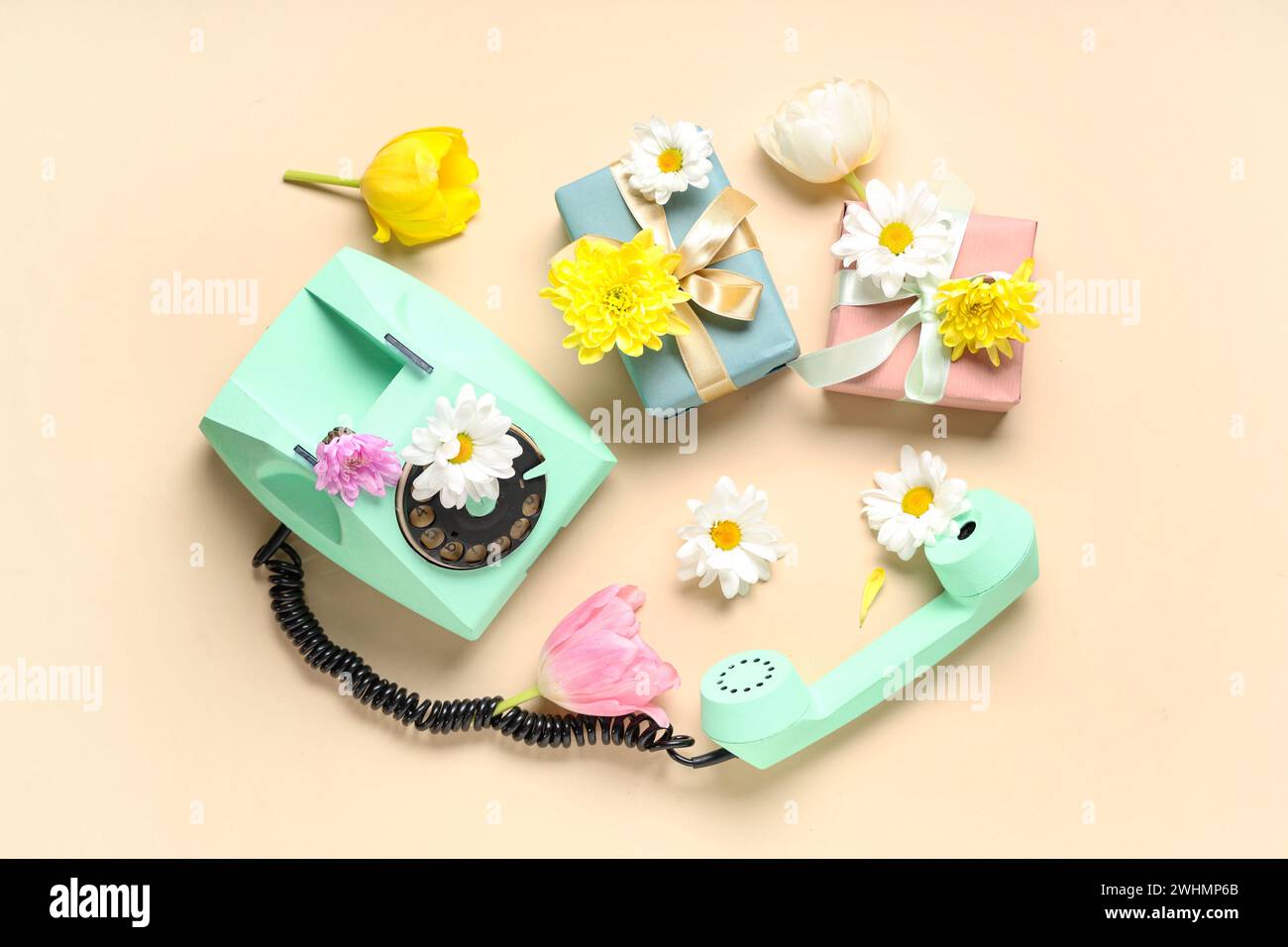 Retro telephone with beautiful flowers and gift boxes on beige ...