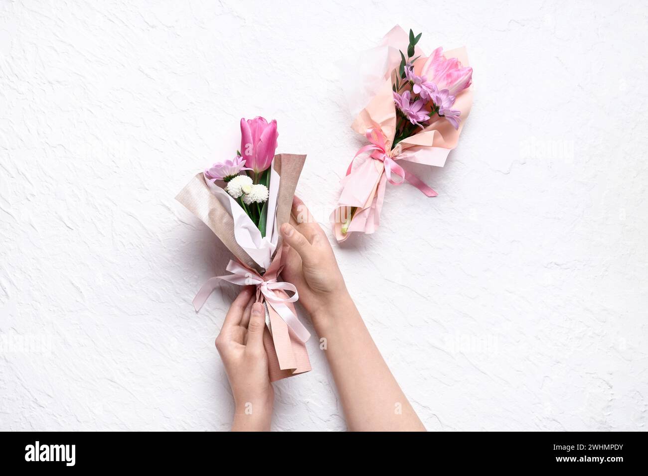Female hands with mini bouquets of beautiful spring flowers in wrapping ...