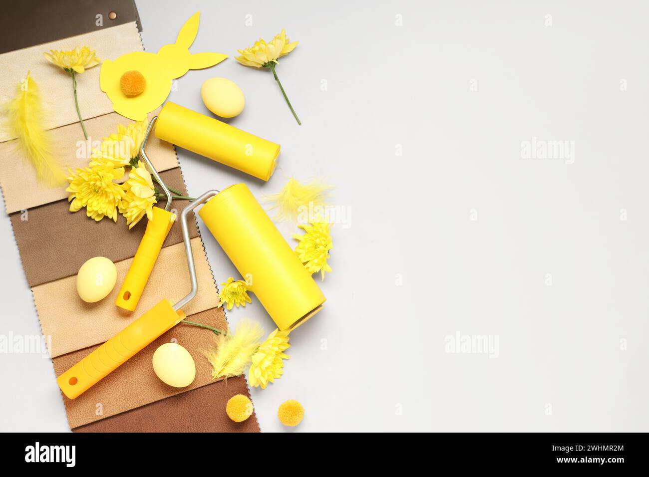 Composition with paint rollers, fabric samples, Easter eggs and flowers ...