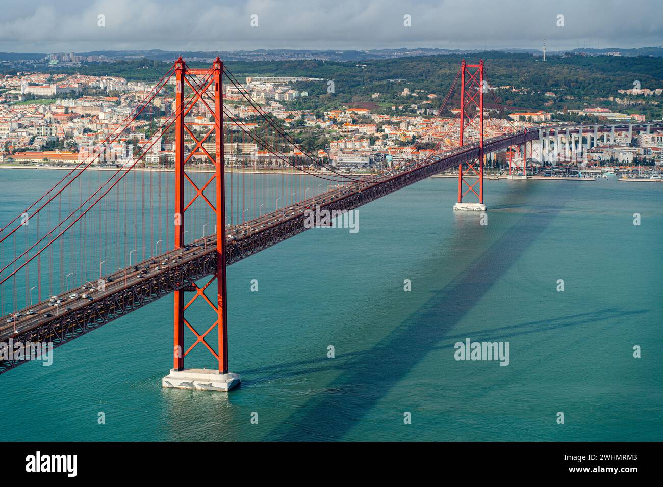 High-angle view of the 25th of April bridge in Lisbon, cloudy sky red ...