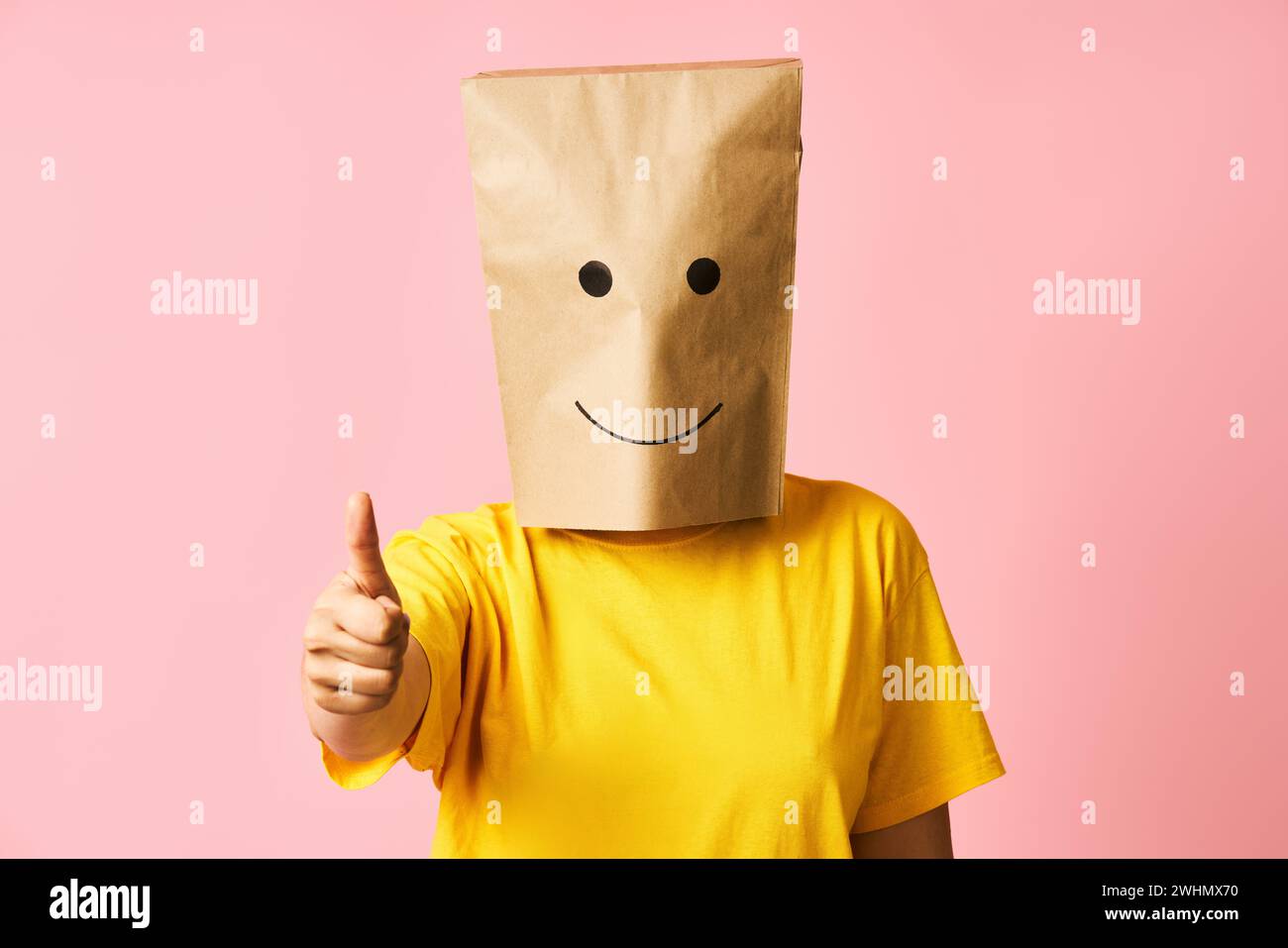 Woman wearing paper bag on head with smile emoticon icons face showing ...
