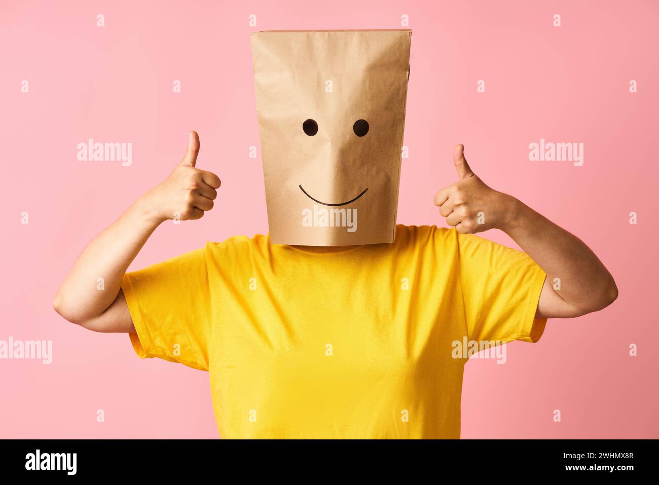Woman wearing paper bag on head with smile emoticon icons face showing ...