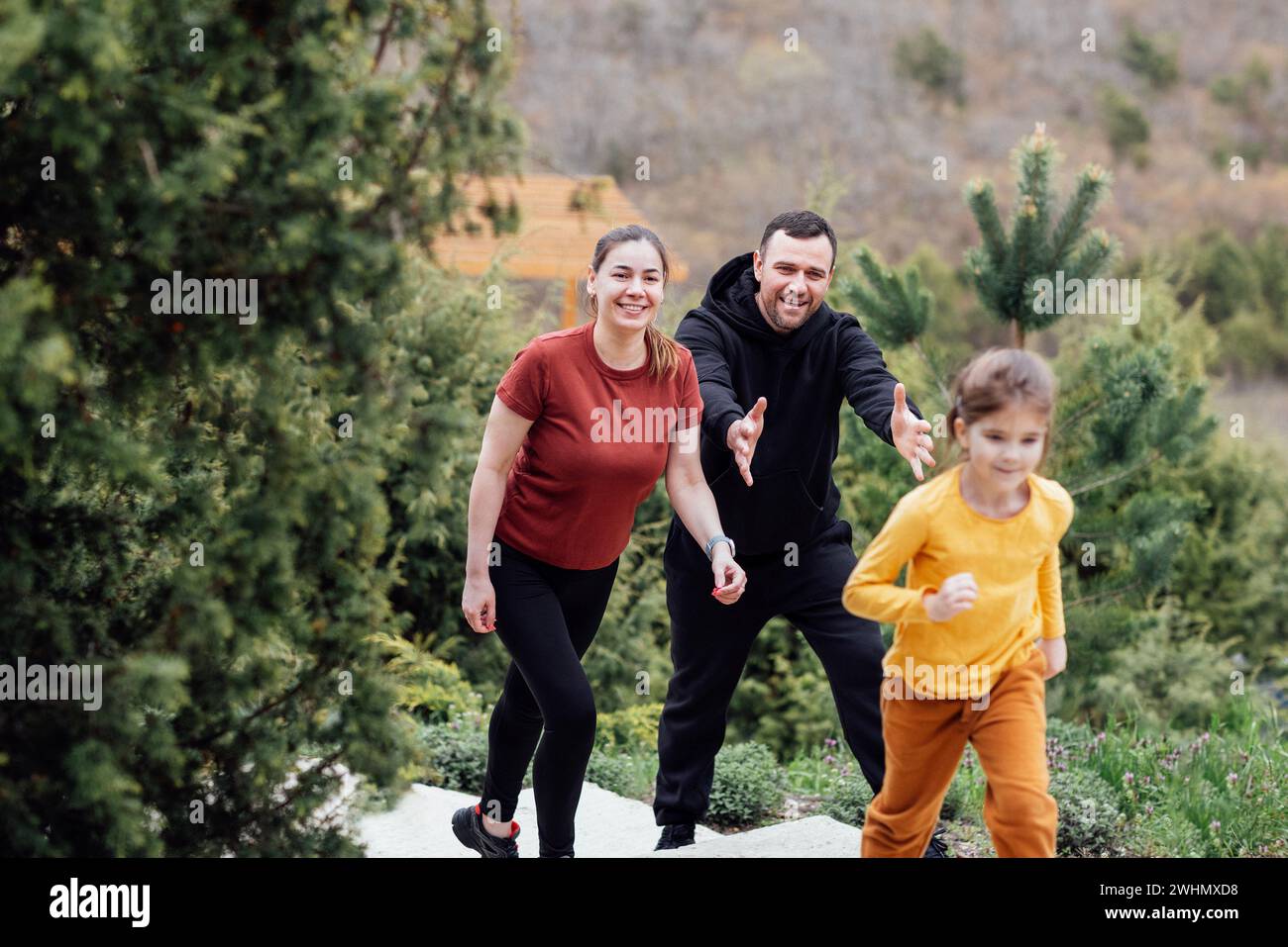 Happy family jogging in the summertime. Smiling young couple with their ...