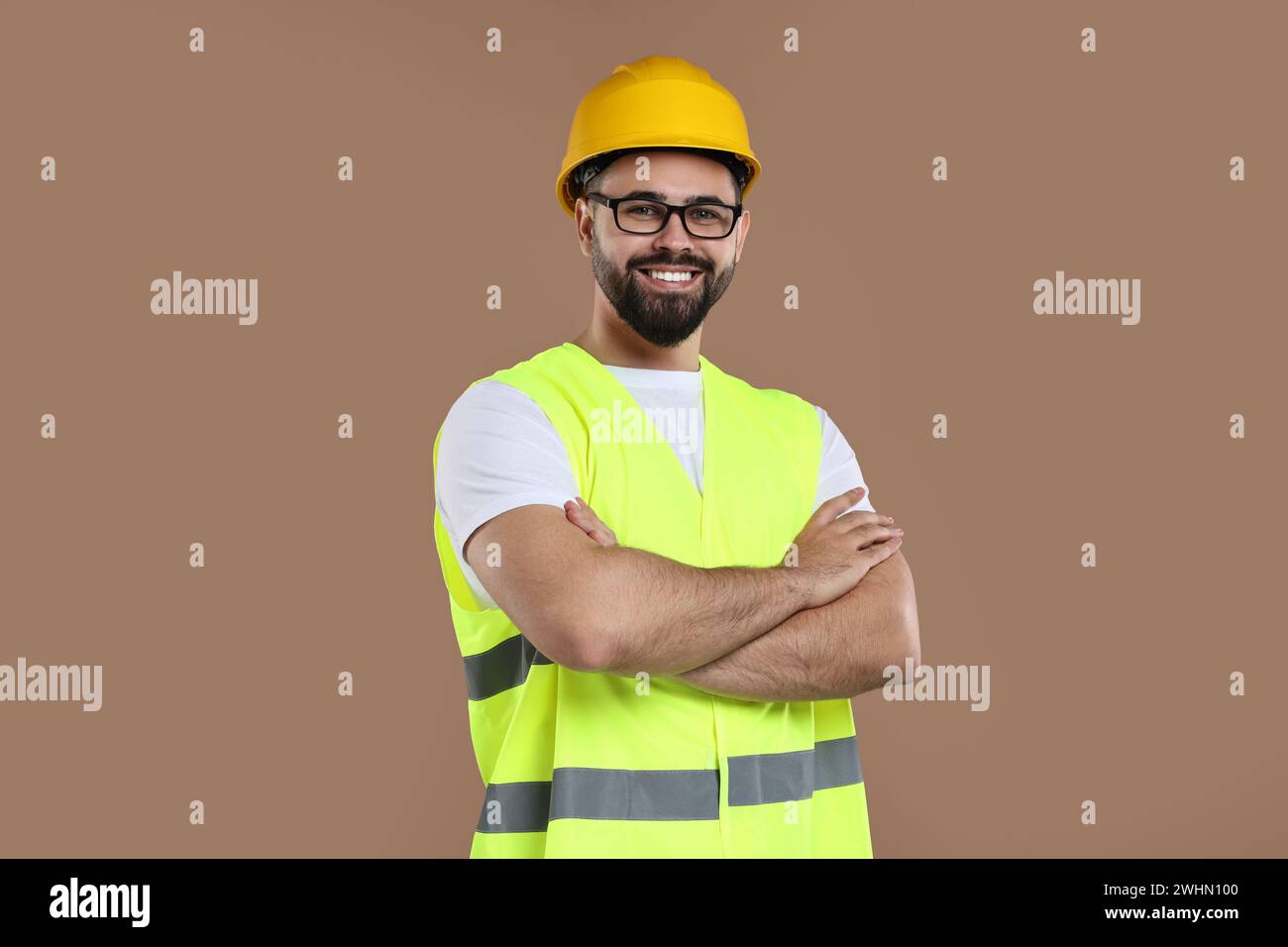Engineer in hard hat on brown background Stock Photo - Alamy