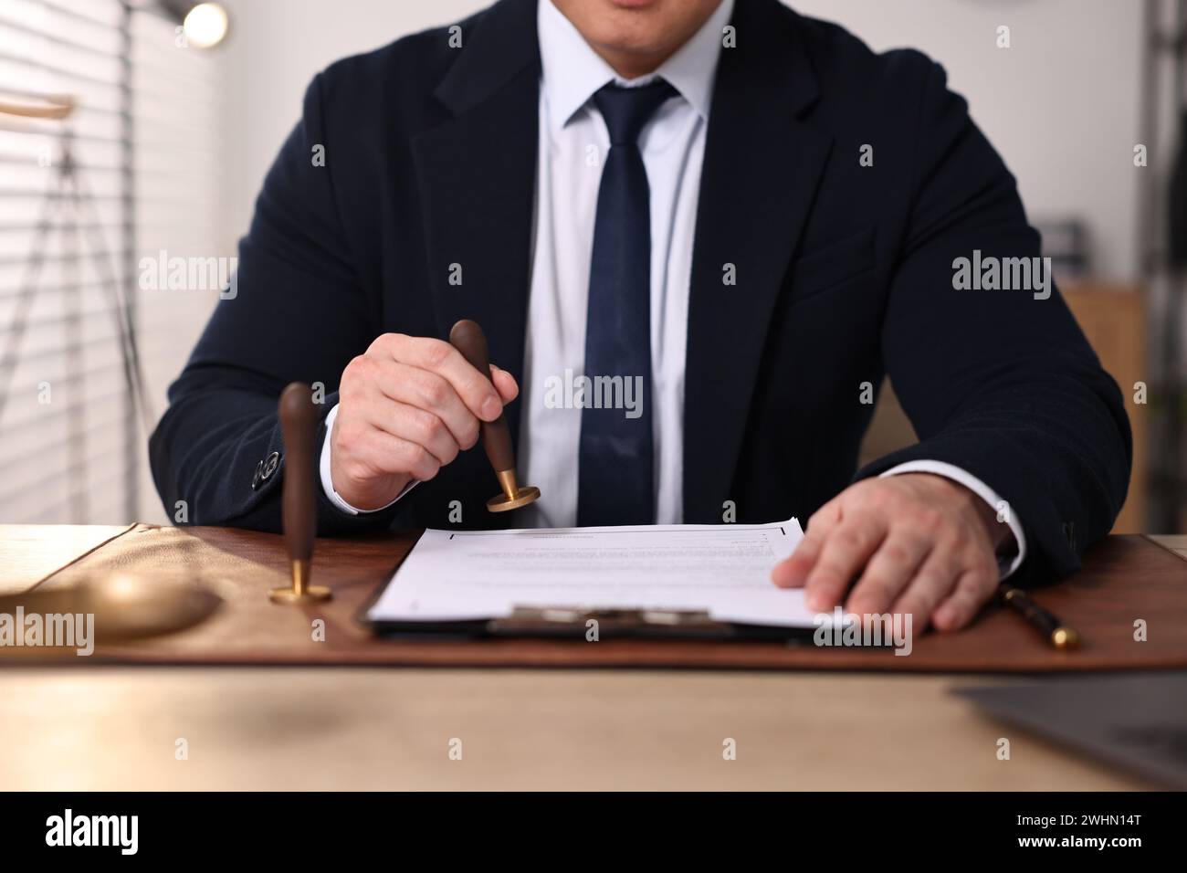 Notary stamping document at wooden table in office, closeup Stock Photo ...
