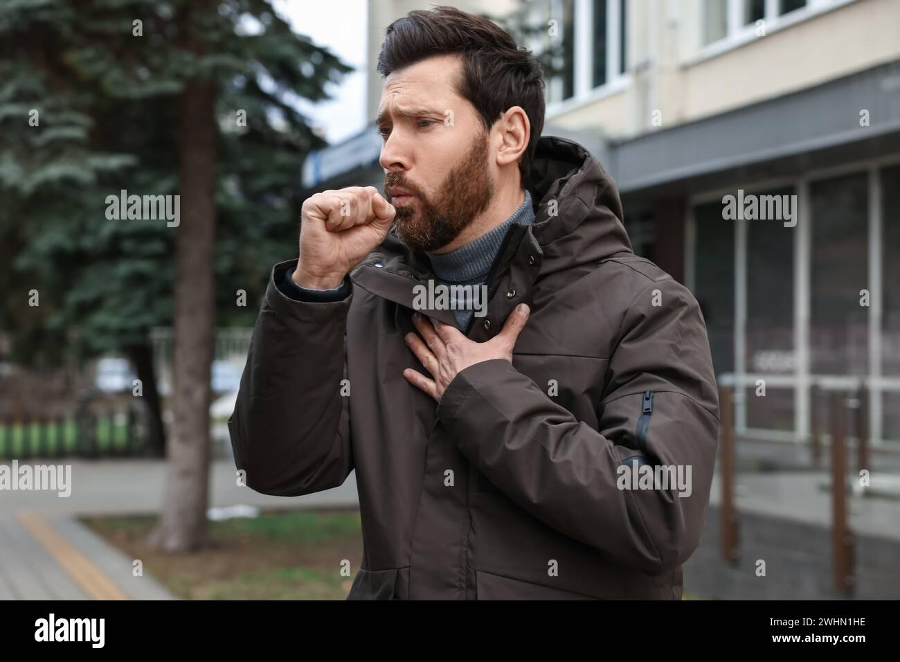 Sick man coughing on city street. Cold symptoms Stock Photo - Alamy