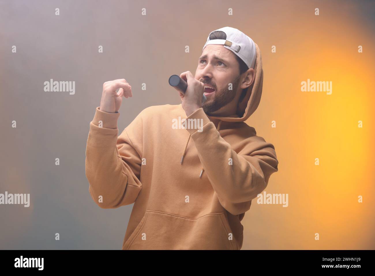 Singer with microphone rapping in color lights Stock Photo - Alamy