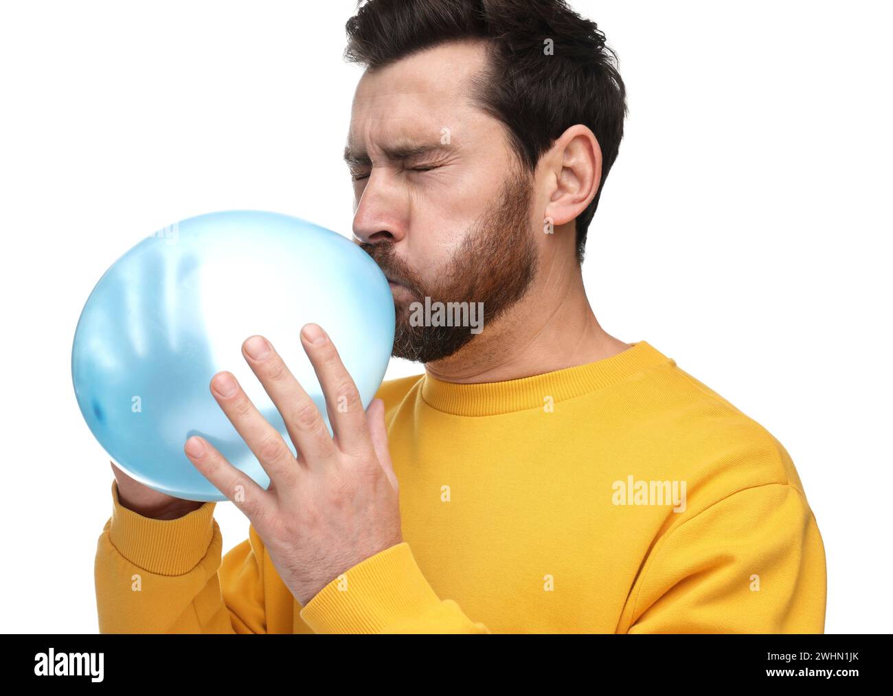 Man inflating light blue balloon on white background Stock Photo - Alamy