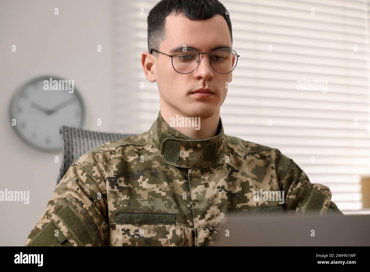 Military service. Young soldier working in office Stock Photo - Alamy