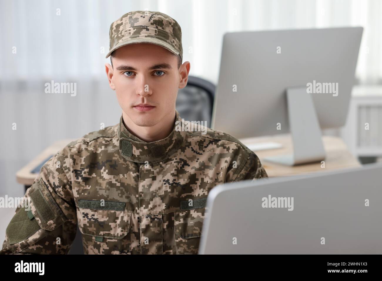 Military service. Young soldier working in office Stock Photo - Alamy