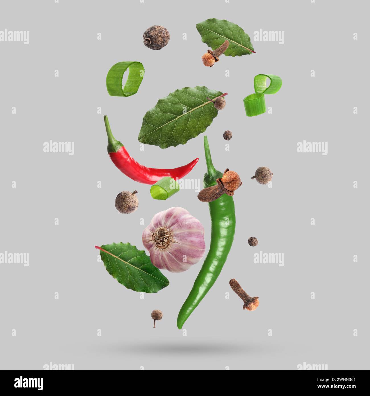 Different spices falling on light grey background Stock Photo - Alamy