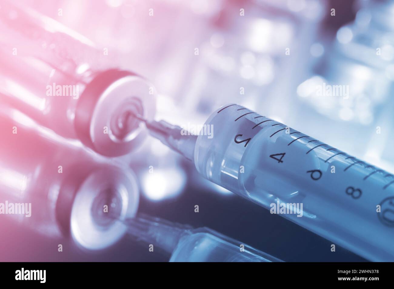 Filling syringe with medicine from vial on mirror surface, closeup ...