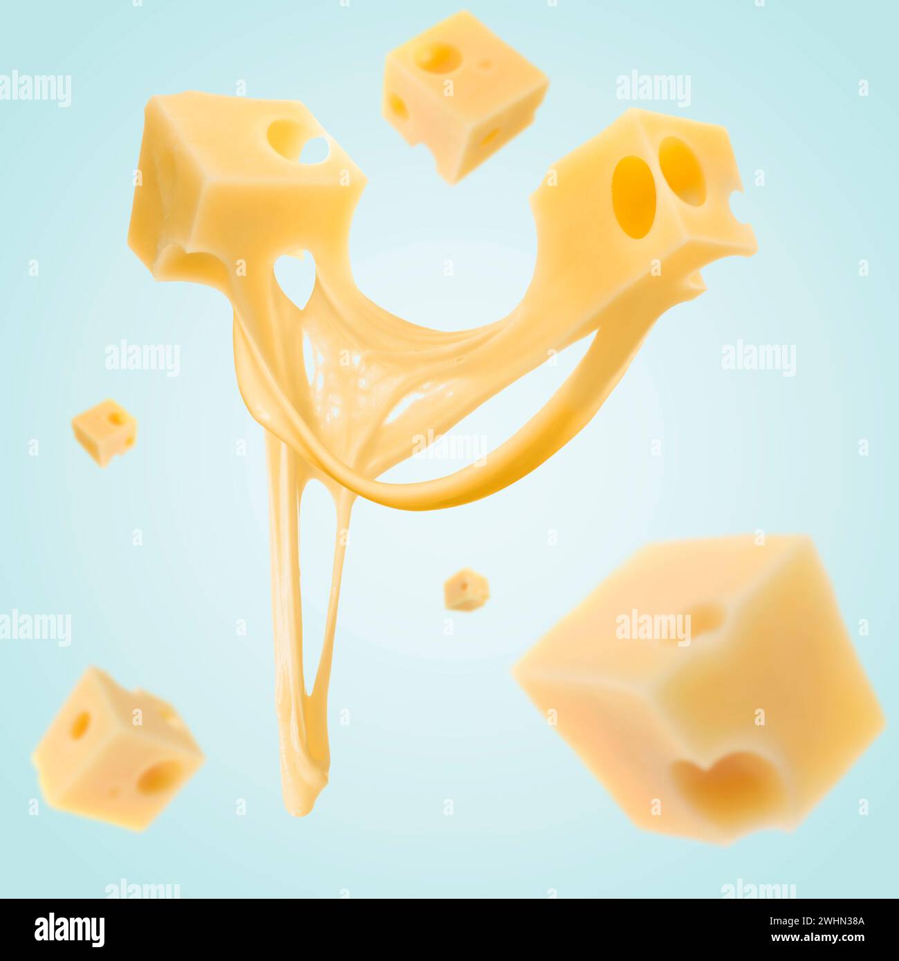 Pieces of cheese falling on light blue background Stock Photo - Alamy