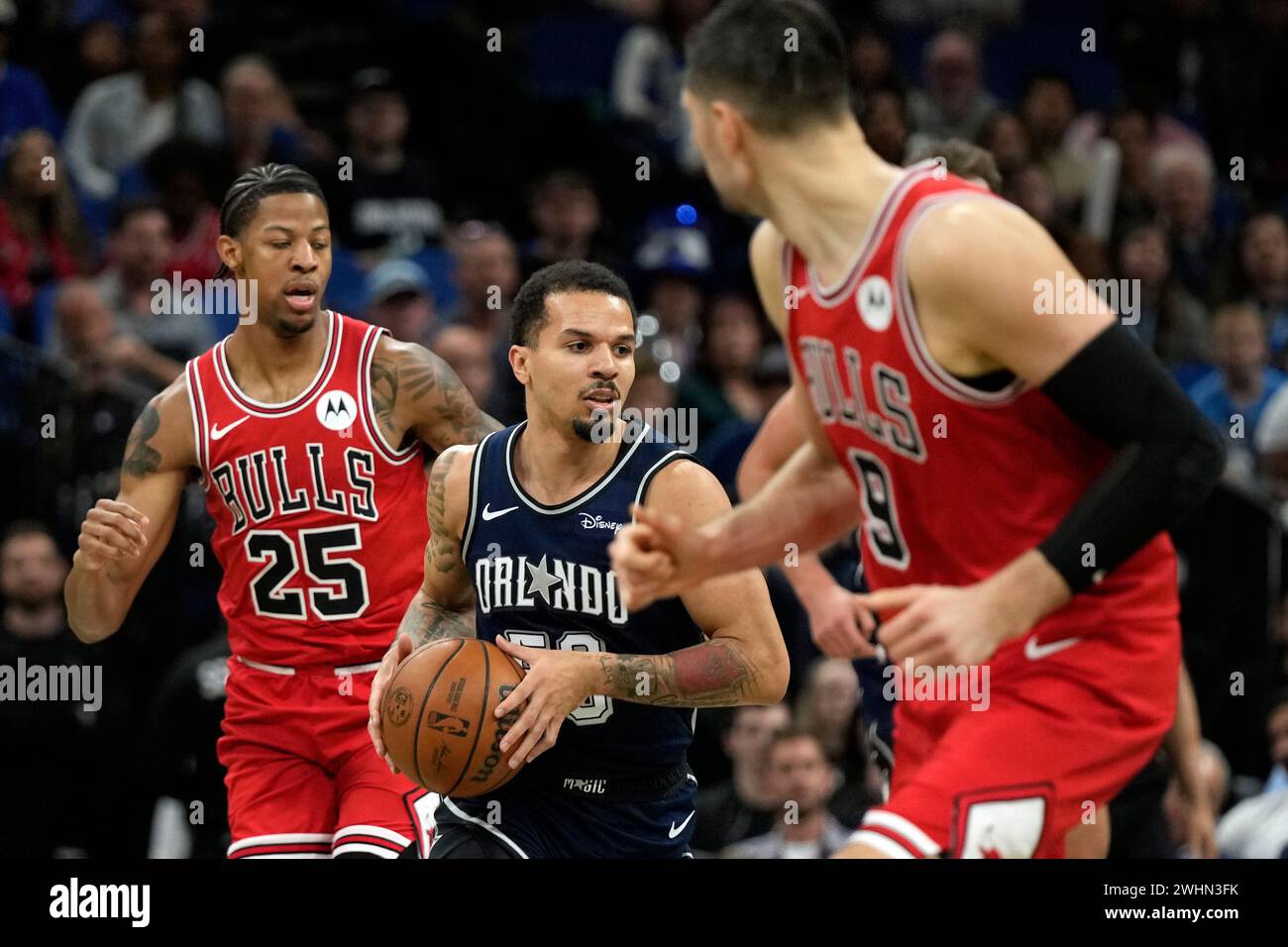 Orlando Magic guard Cole Anthony, center, moves the ball between ...