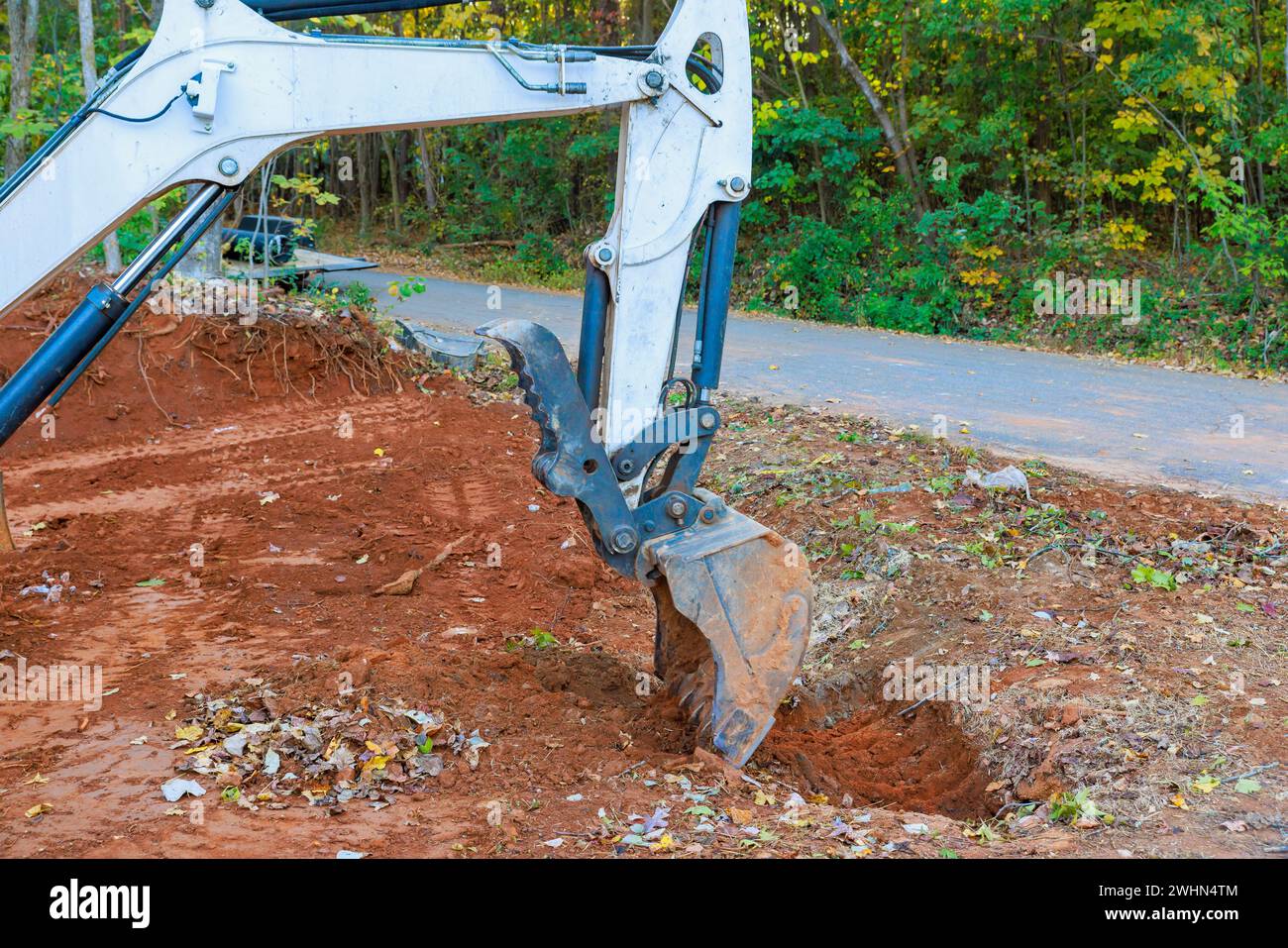 Excavator dig trenches to lay pipe through which rainwater will flow to ...