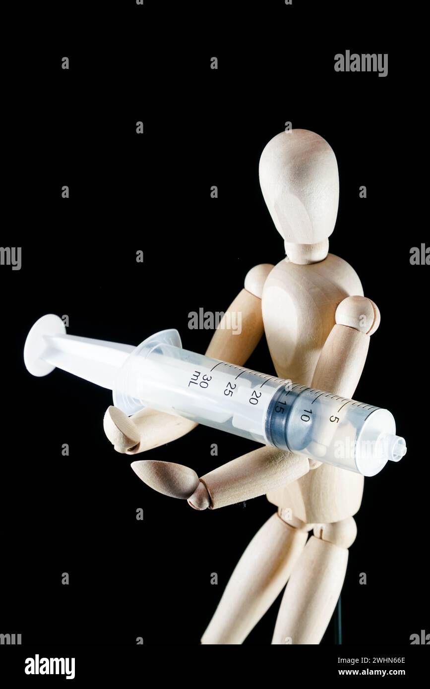 Wooden dummy figurine and syringe, medical concept, vaccine concept ...