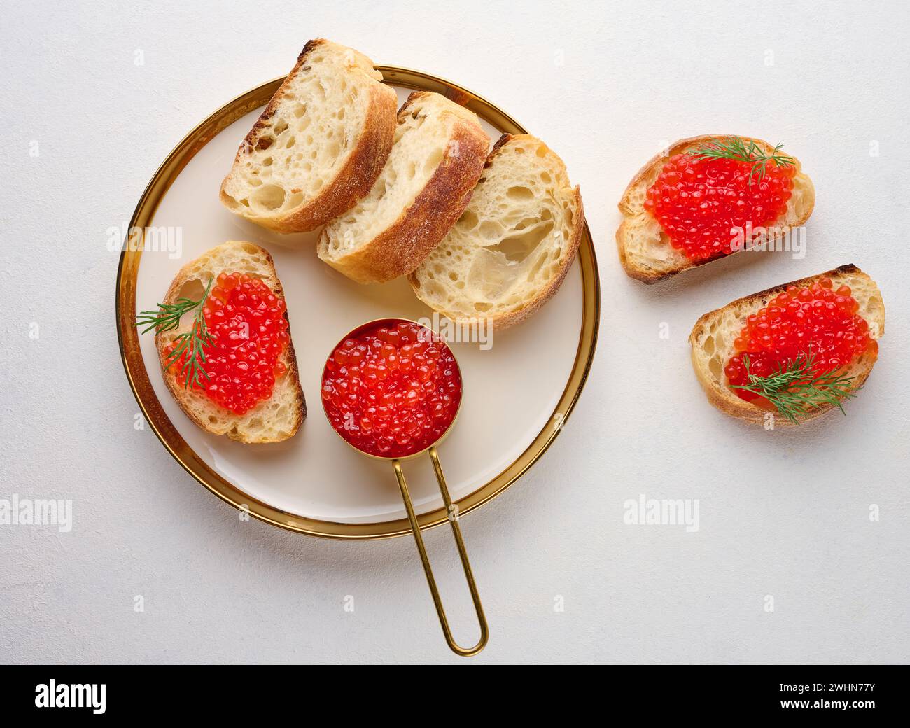 Sandwiches with red caviar and bread in a round plate on a white table ...