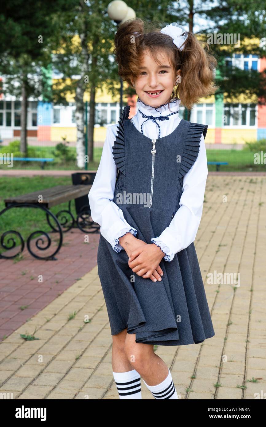 Cheerful funny girl with a toothless smile in a school uniform with ...