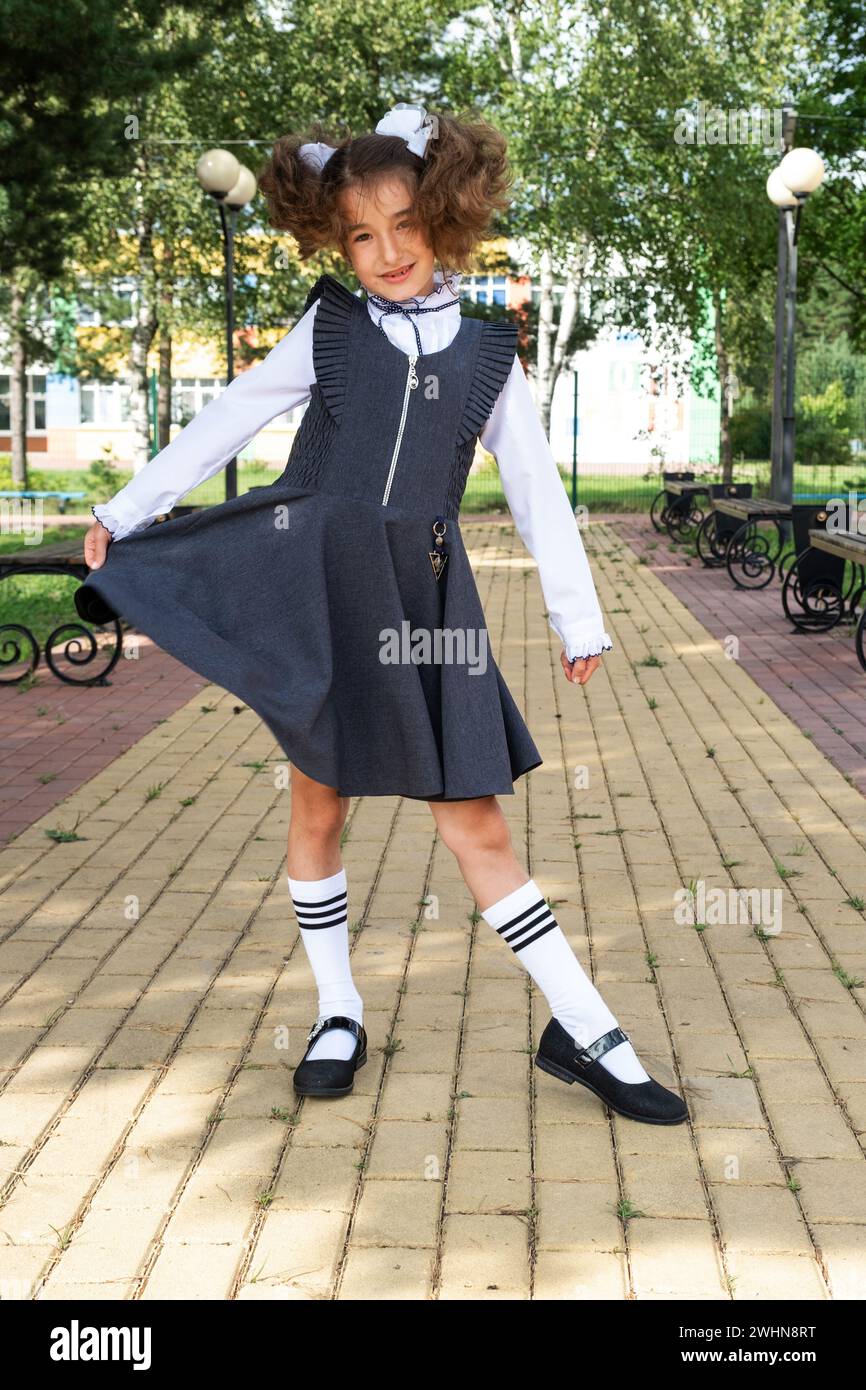 Cheerful funny girl with a toothless smile in a school uniform with ...