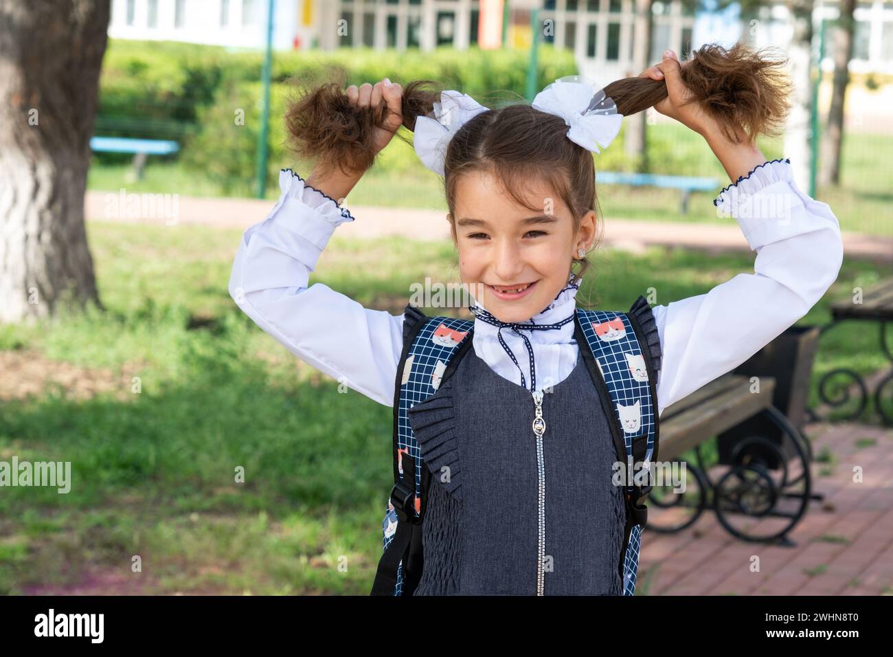 Cheerful funny girl with a toothless smile in a school uniform with ...