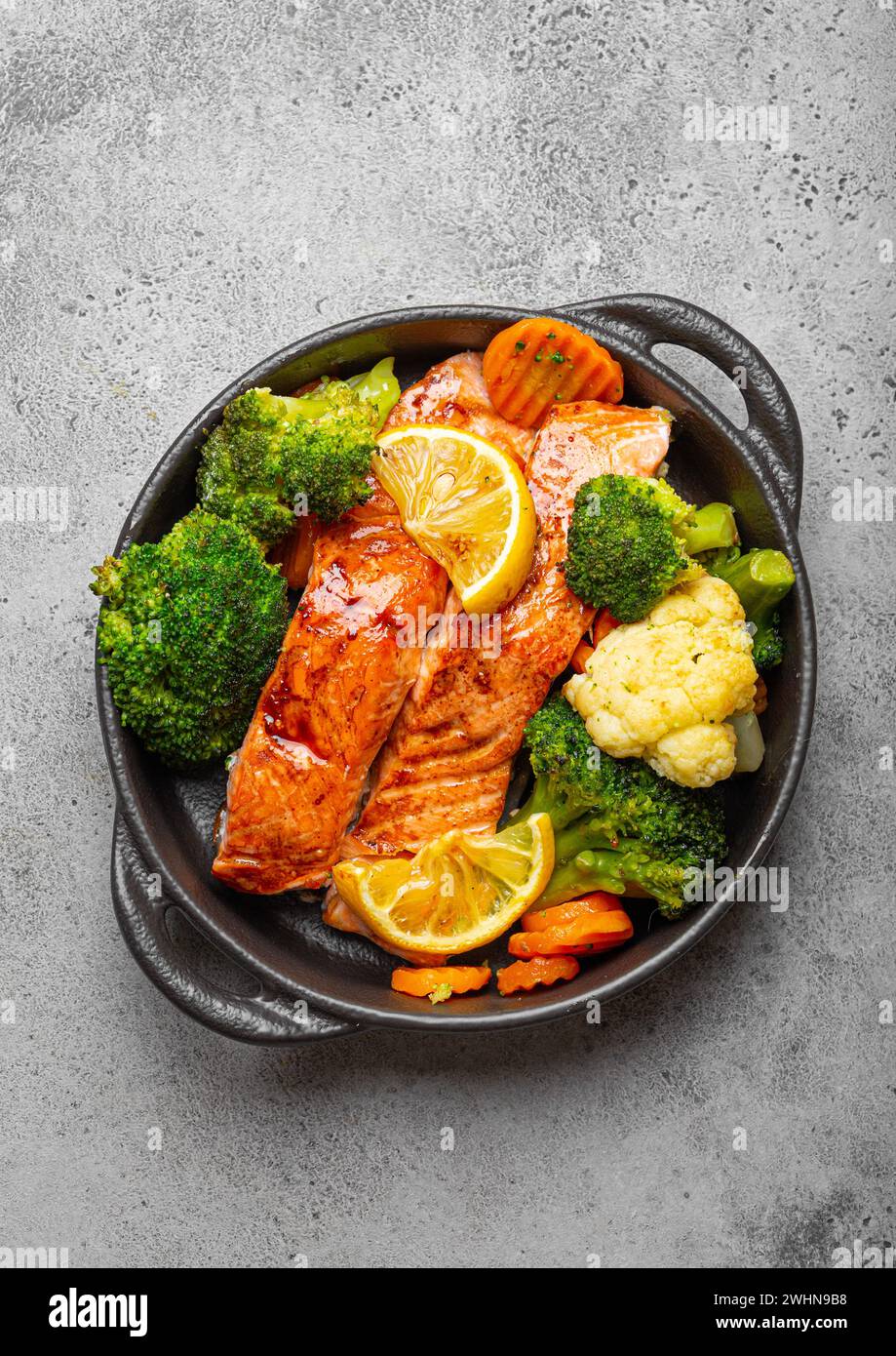 Healthy baked fish salmon steaks, broccoli, cauliflower, carrot in ...