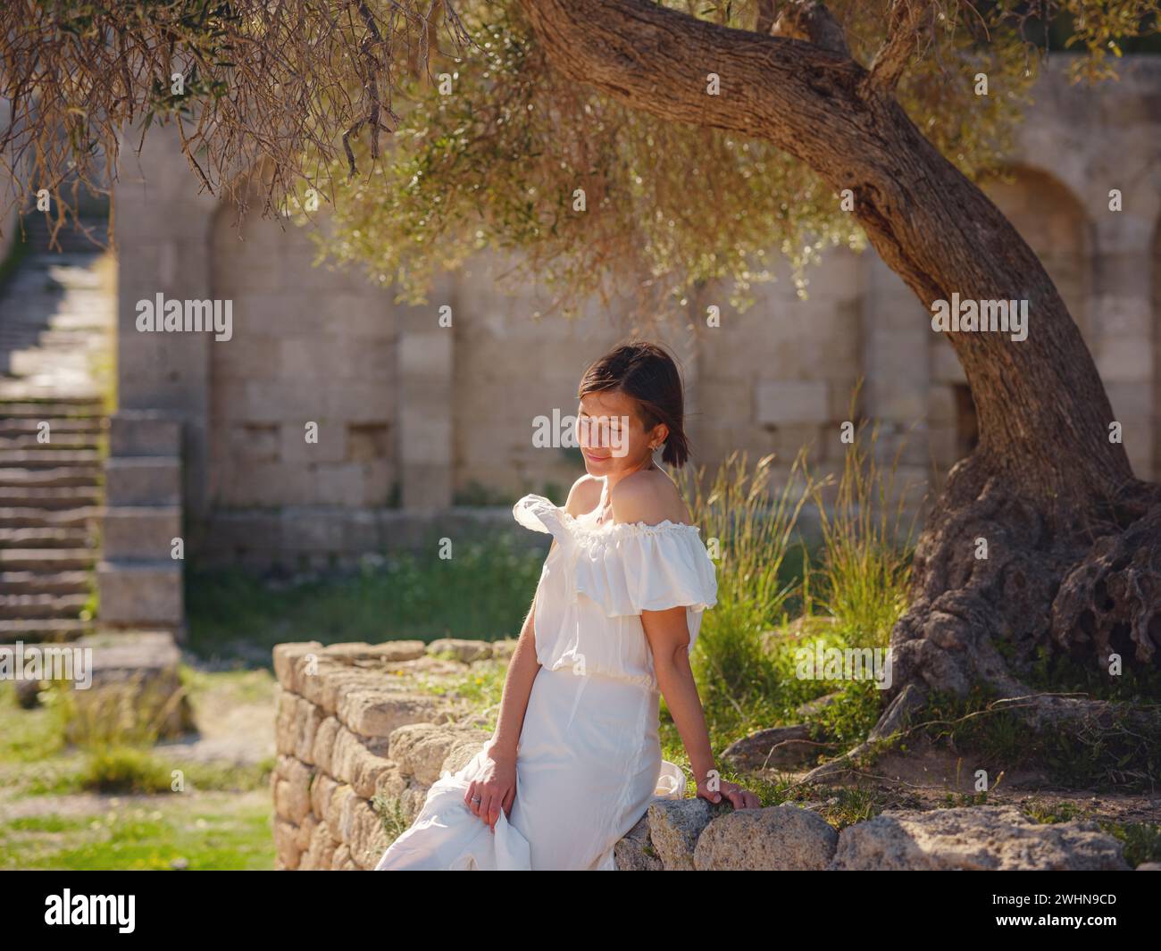 Beautiful Asian young woman in white dress outdoor. Acropolis of Rhodes ...