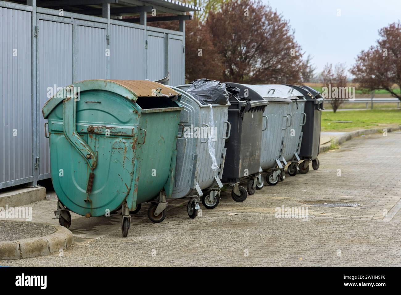 For repair junk waste, there is metal container dumpster bin near house ...