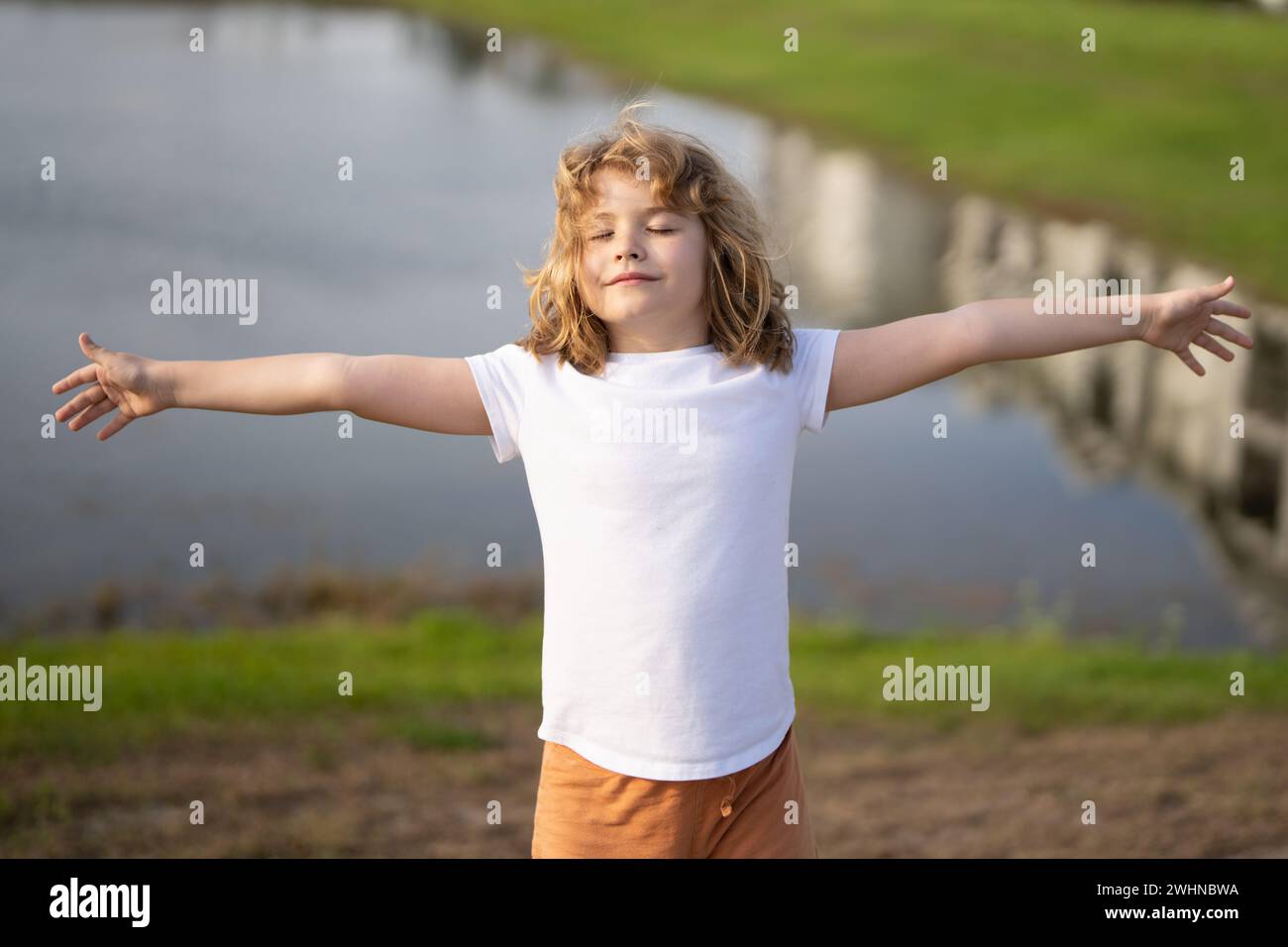 Kid with arms up enjoying freedom in nature. Child open arms enjoying ...